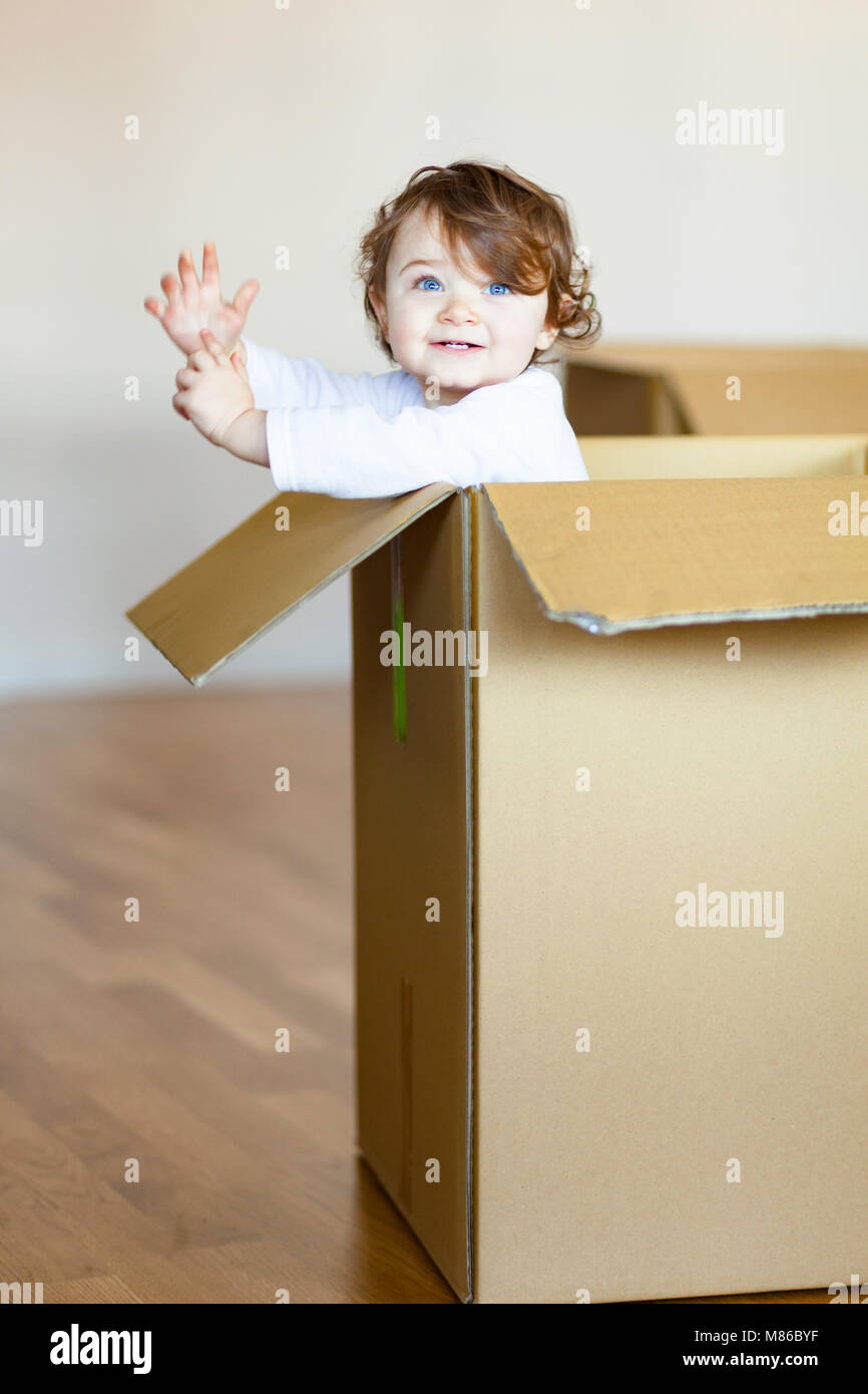Cute smiling toddler baby girl sitting inside brown cardboard box Stock ...