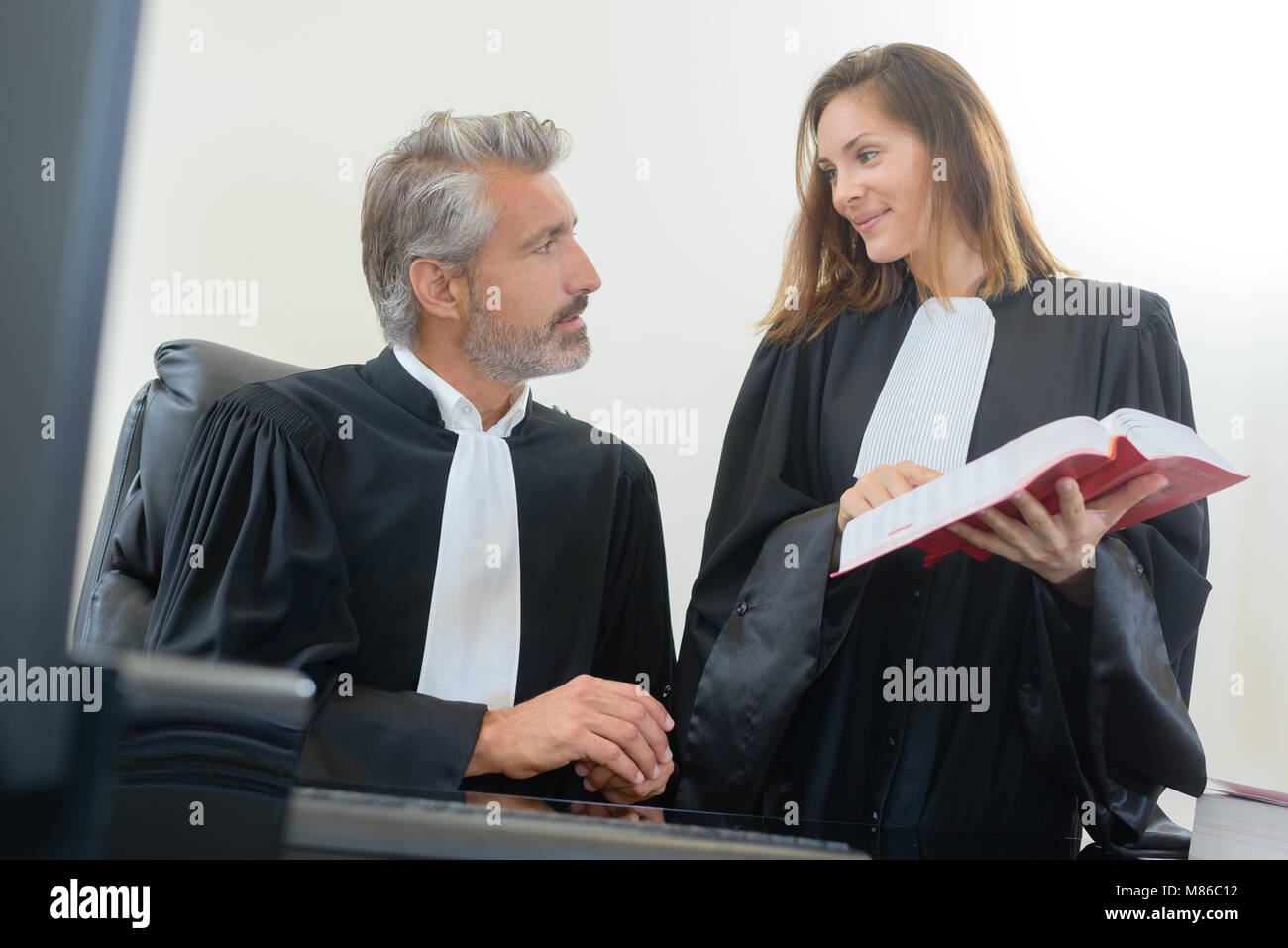 Judges looking at red book Stock Photo - Alamy
