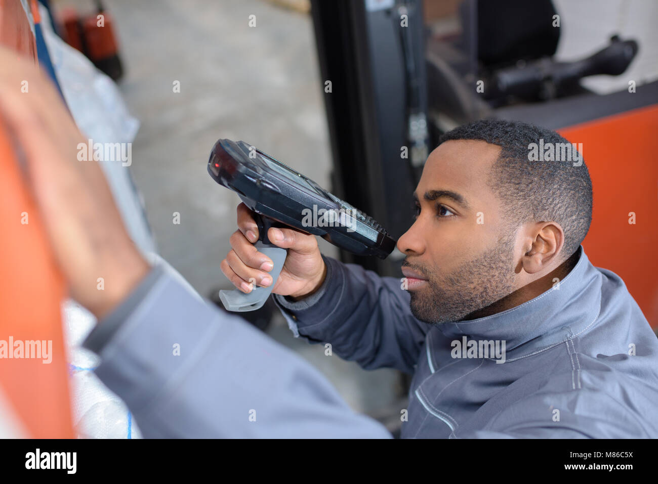 Worker using handheld scanner Stock Photo - Alamy