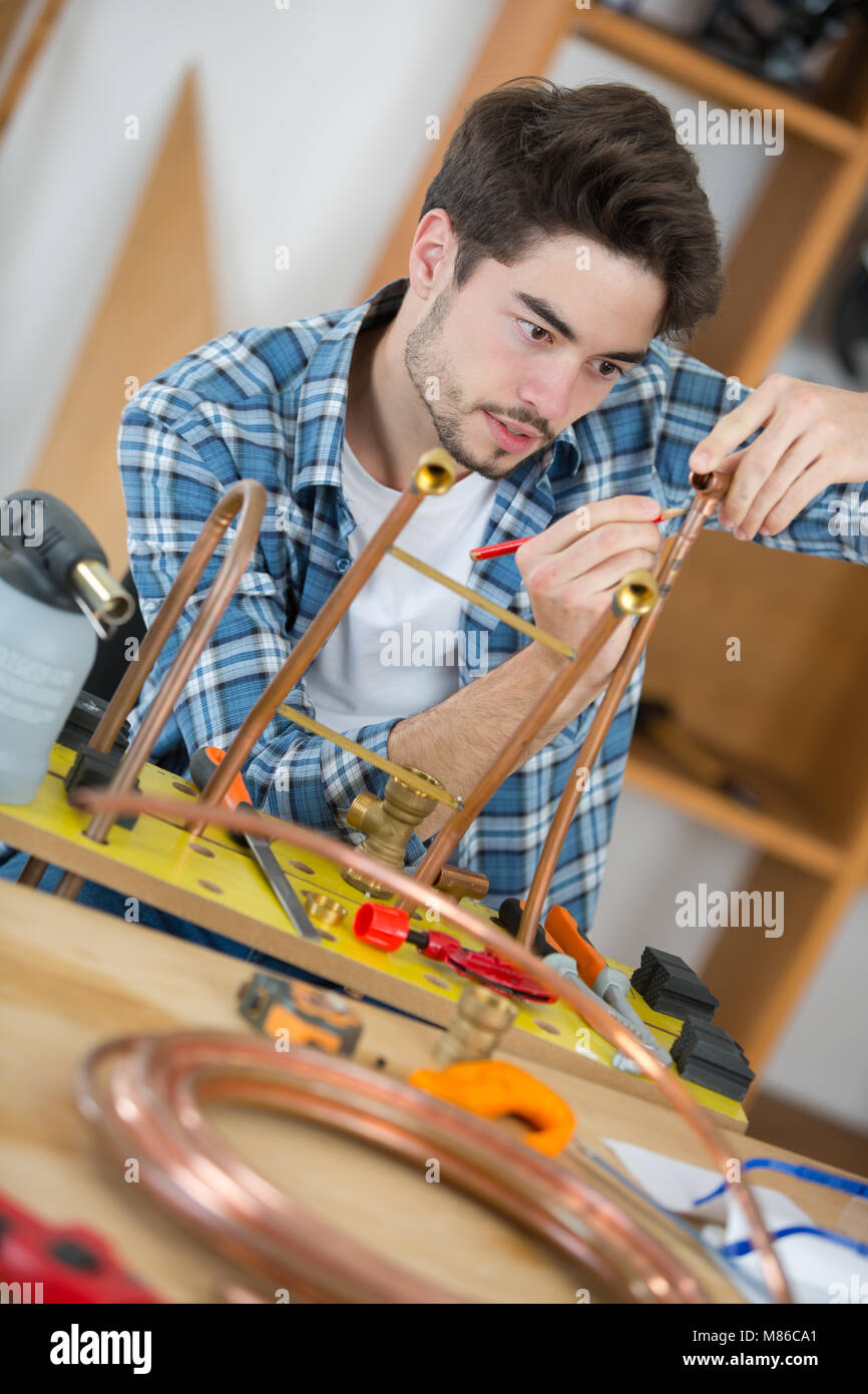 plumber marking copper pipe Stock Photo - Alamy