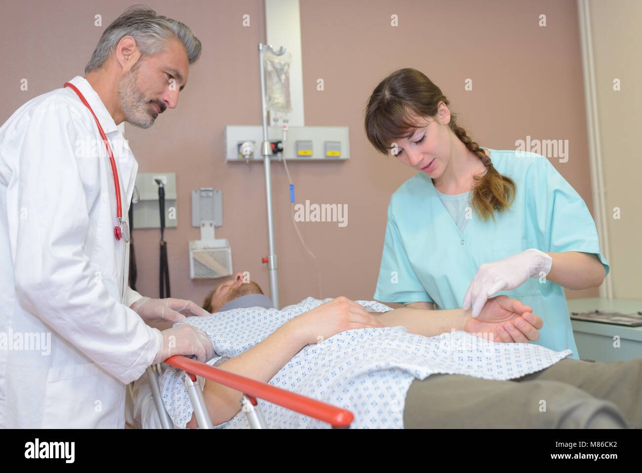 medical team inspecting the patients injuries Stock Photo - Alamy