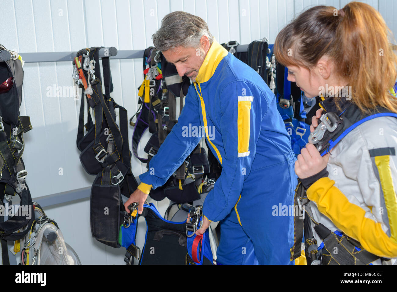 male instructor with female student preparing before skydiving Stock ...