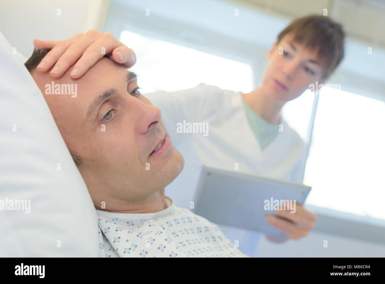 Nurse feeling patient's forehead Stock Photo - Alamy