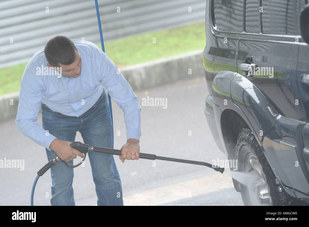 carwash - man working with high pressure washer Stock Photo - Alamy