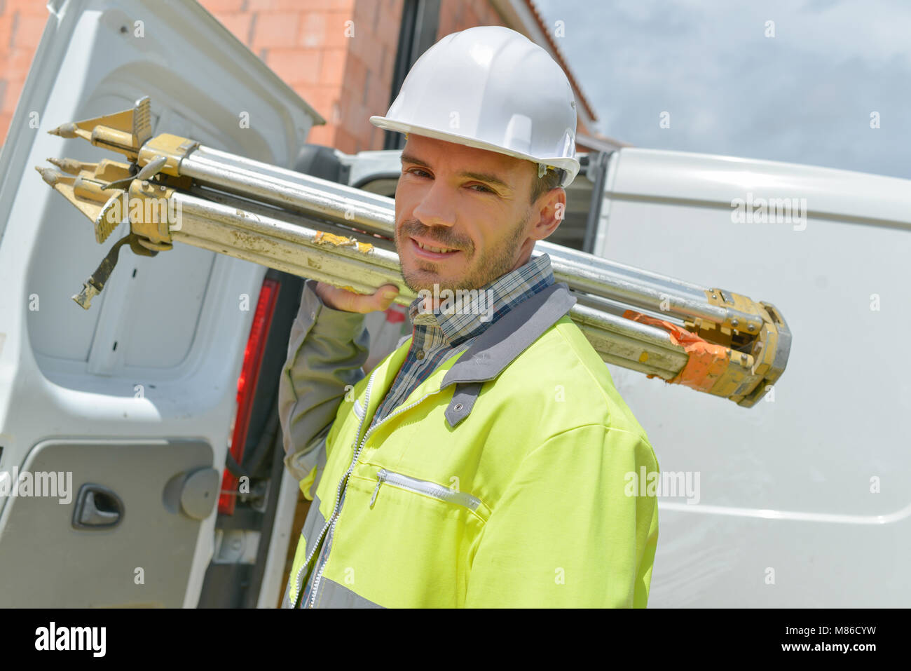 happy builder carrying metal support Stock Photo - Alamy
