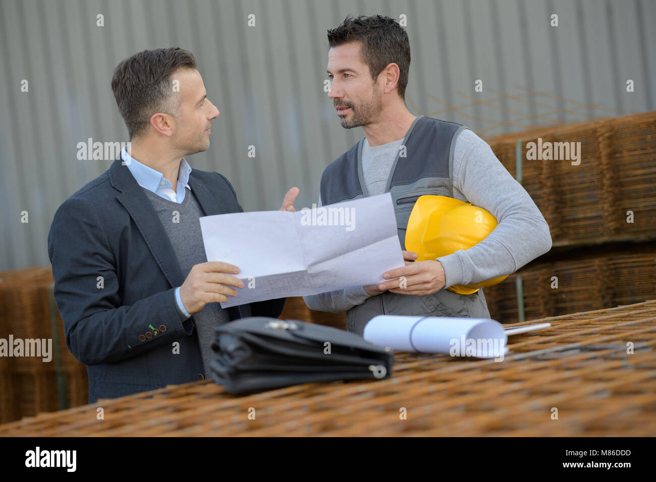 Man in hard hat talking to man in suit hi-res stock photography and ...