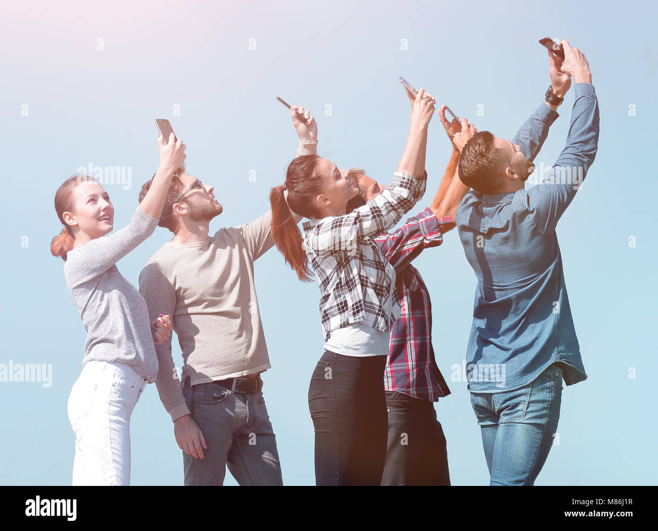rear view. happy friends doing a selfie Stock Photo - Alamy