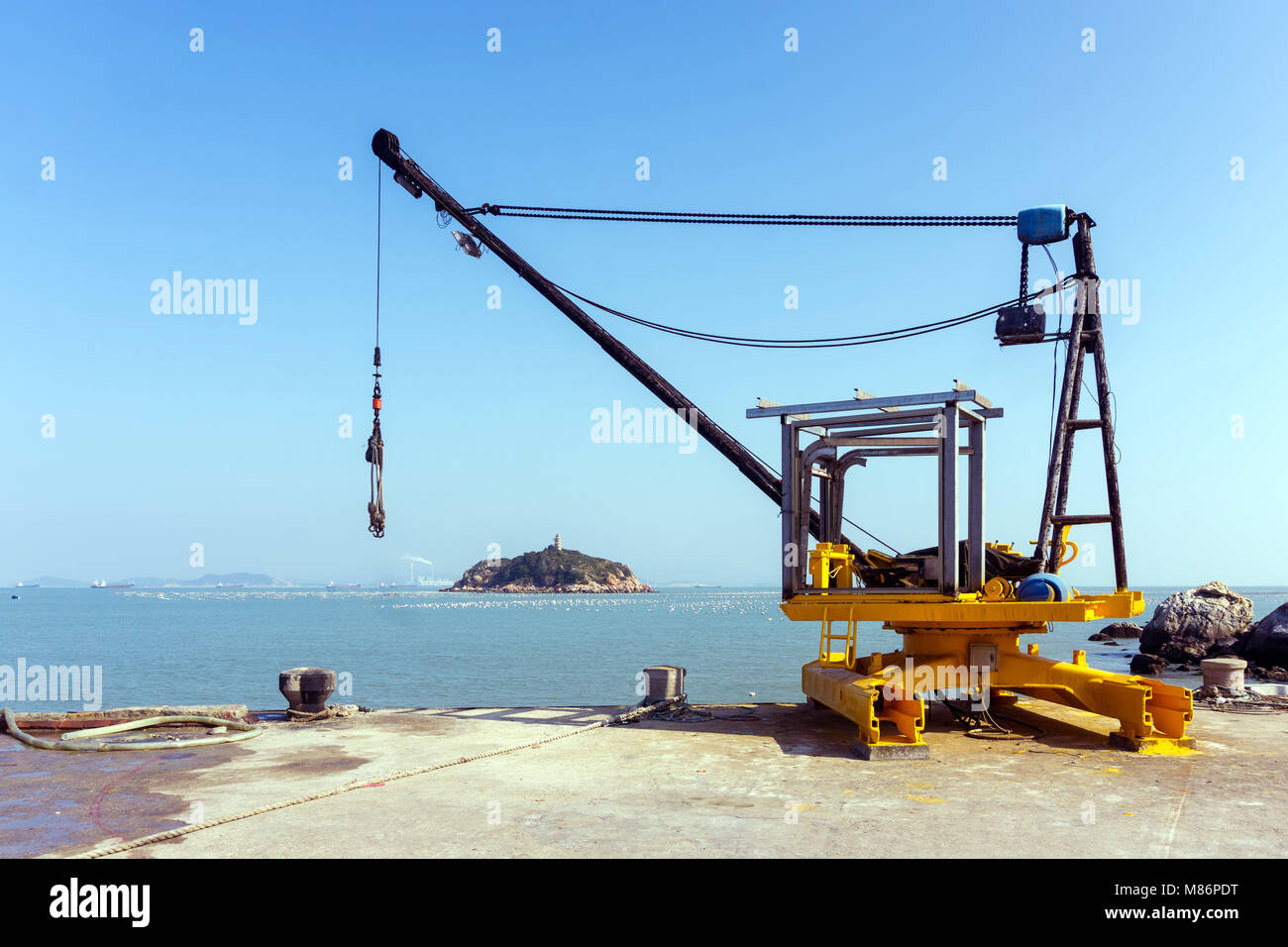 Fishing boat dock, crane against blue sky background Stock Photo - Alamy