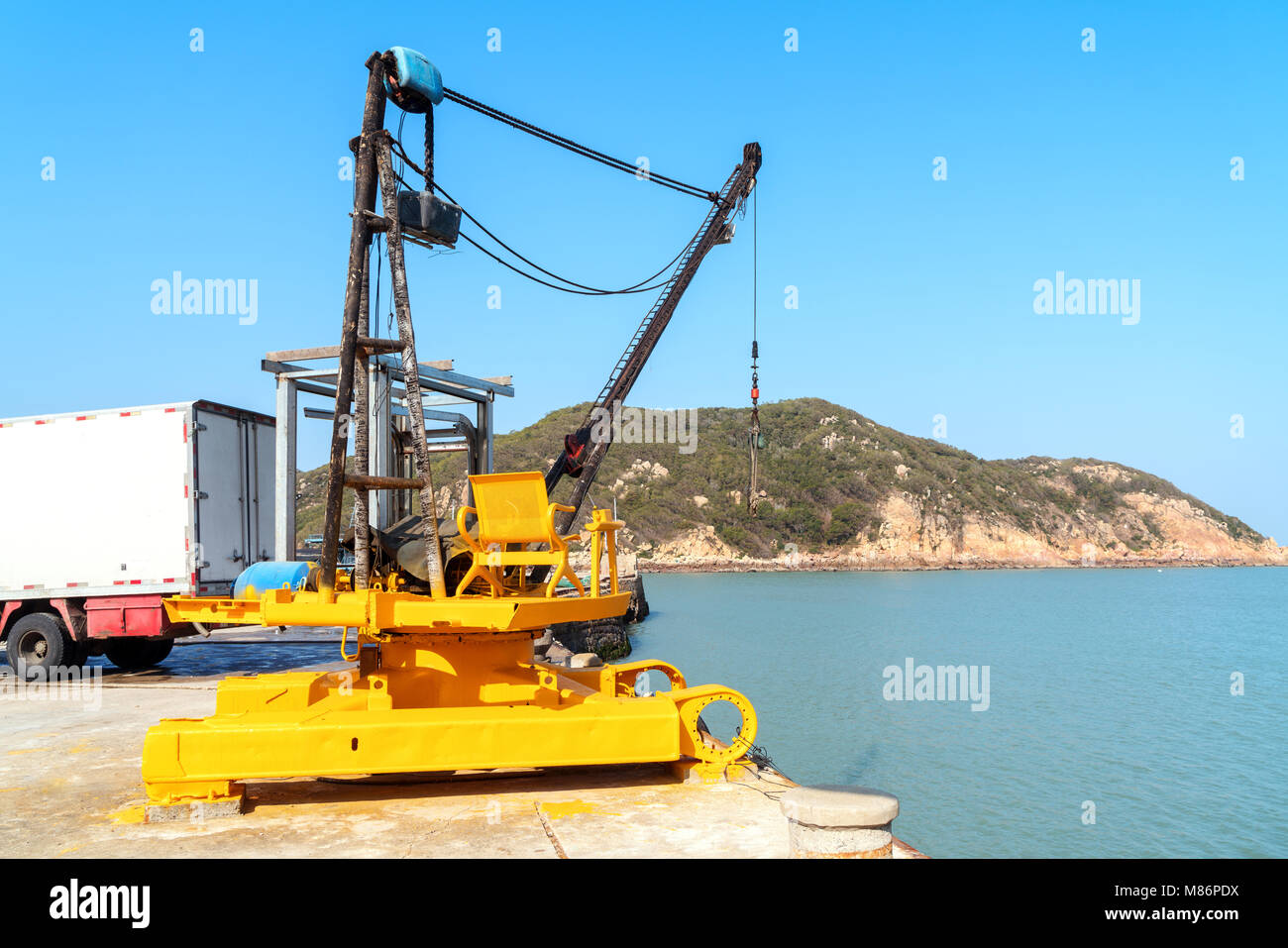 Fishing boat dock, crane against blue sky background Stock Photo - Alamy
