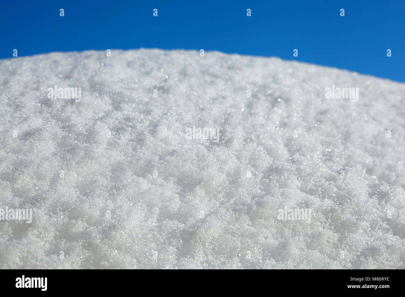 Closeup white snow detail structure with blue sky Stock Photo - Alamy