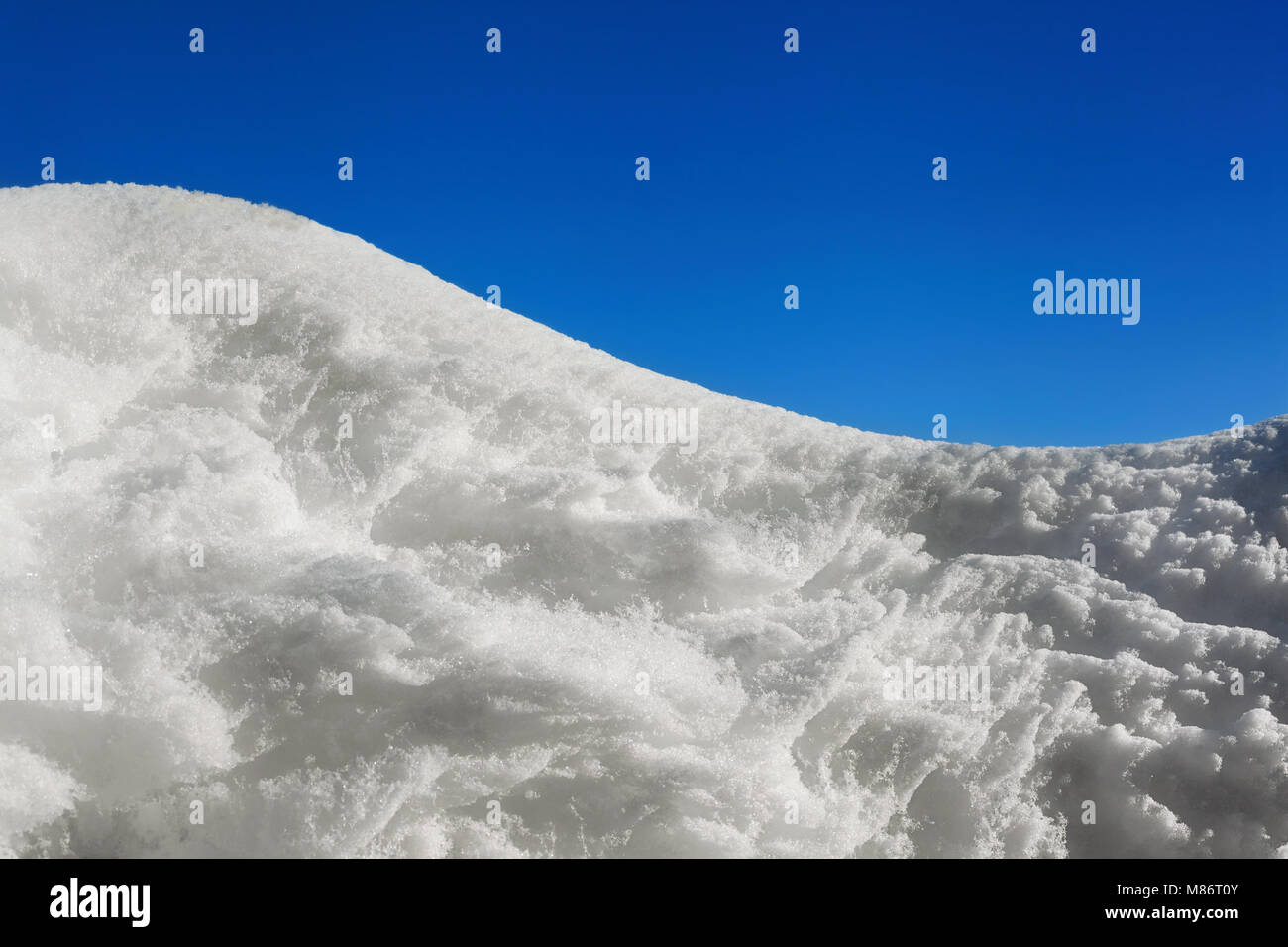 Closeup white snow detail structure with blue sky Stock Photo - Alamy