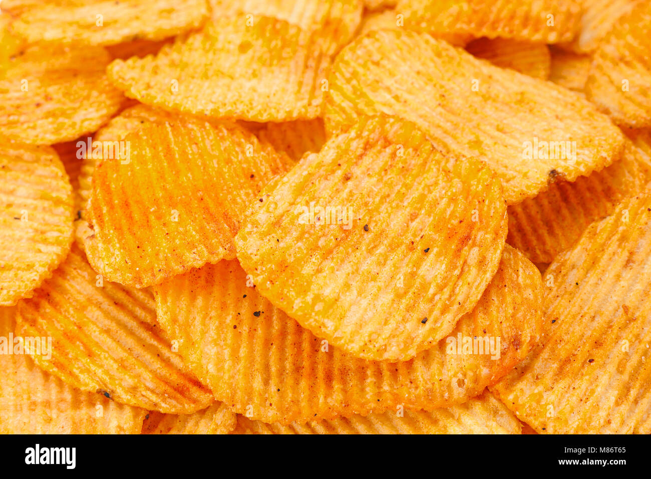 Orange pepper potato chips closeup textured background Stock Photo - Alamy