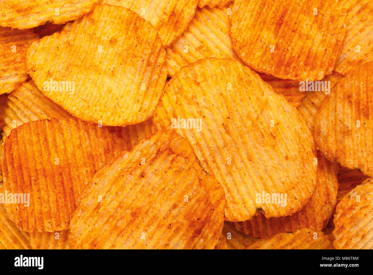 Orange pepper potato chips closeup textured background Stock Photo - Alamy