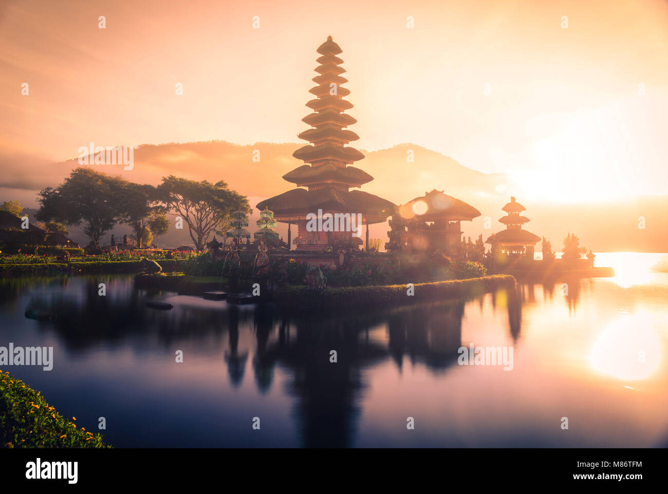 Pura Ulun Danu Bratan, Hindu temple on Bratan lake landscape with lens flare at sunrise in Bali ...