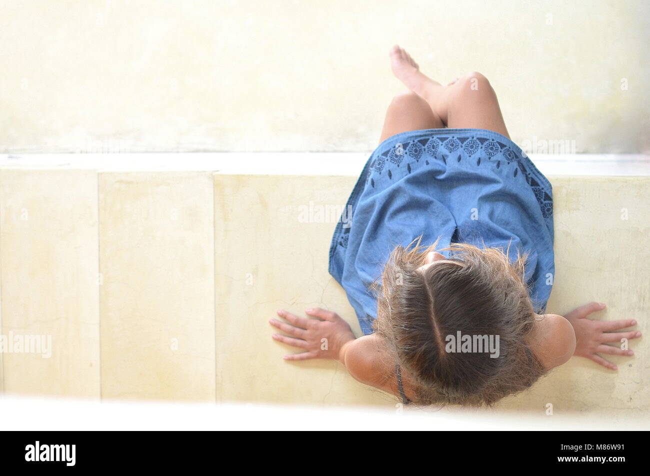 Overhead view of a girl sitting on steps Stock Photo - Alamy