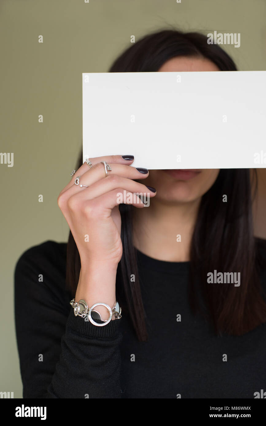Portrait of a woman holding a blank envelope in front of her face Stock ...