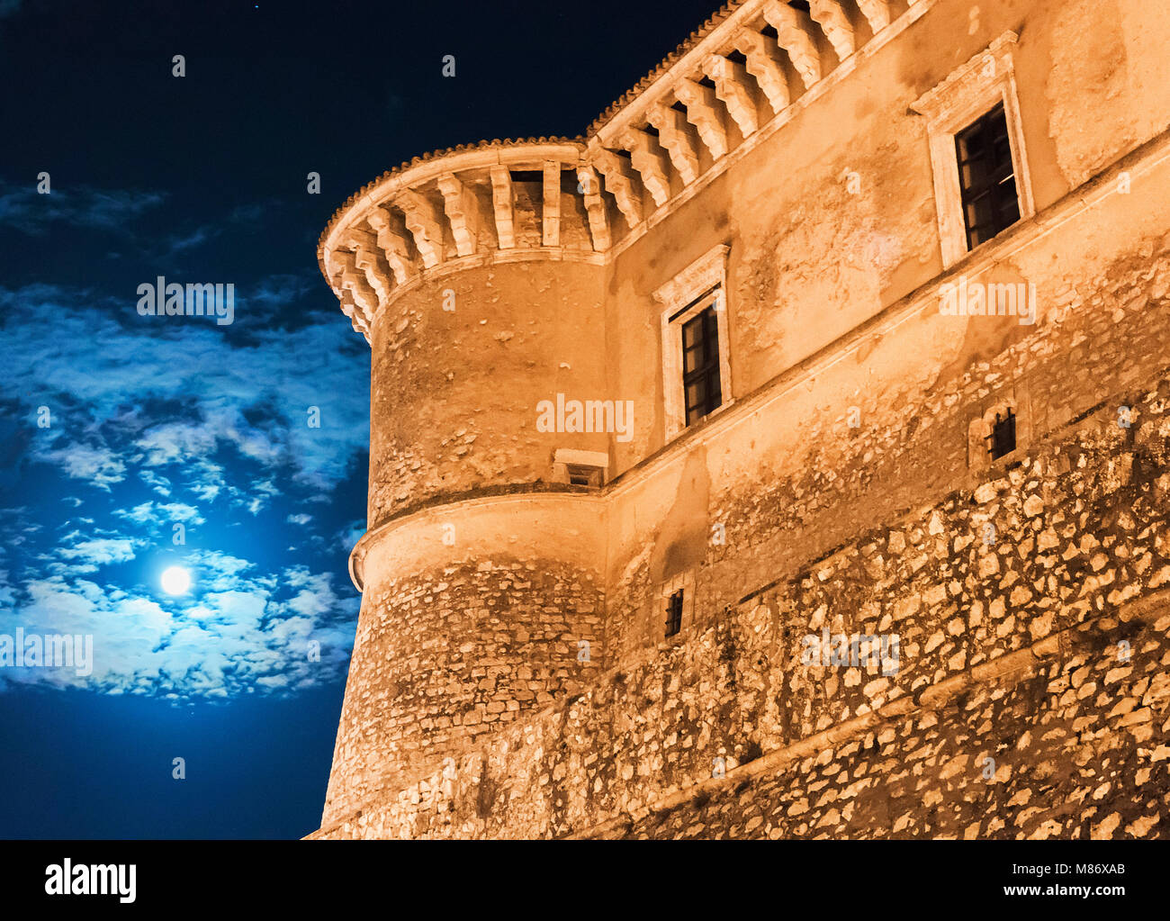 night view of the Alviano medieval castle in Italy with clouds and ...