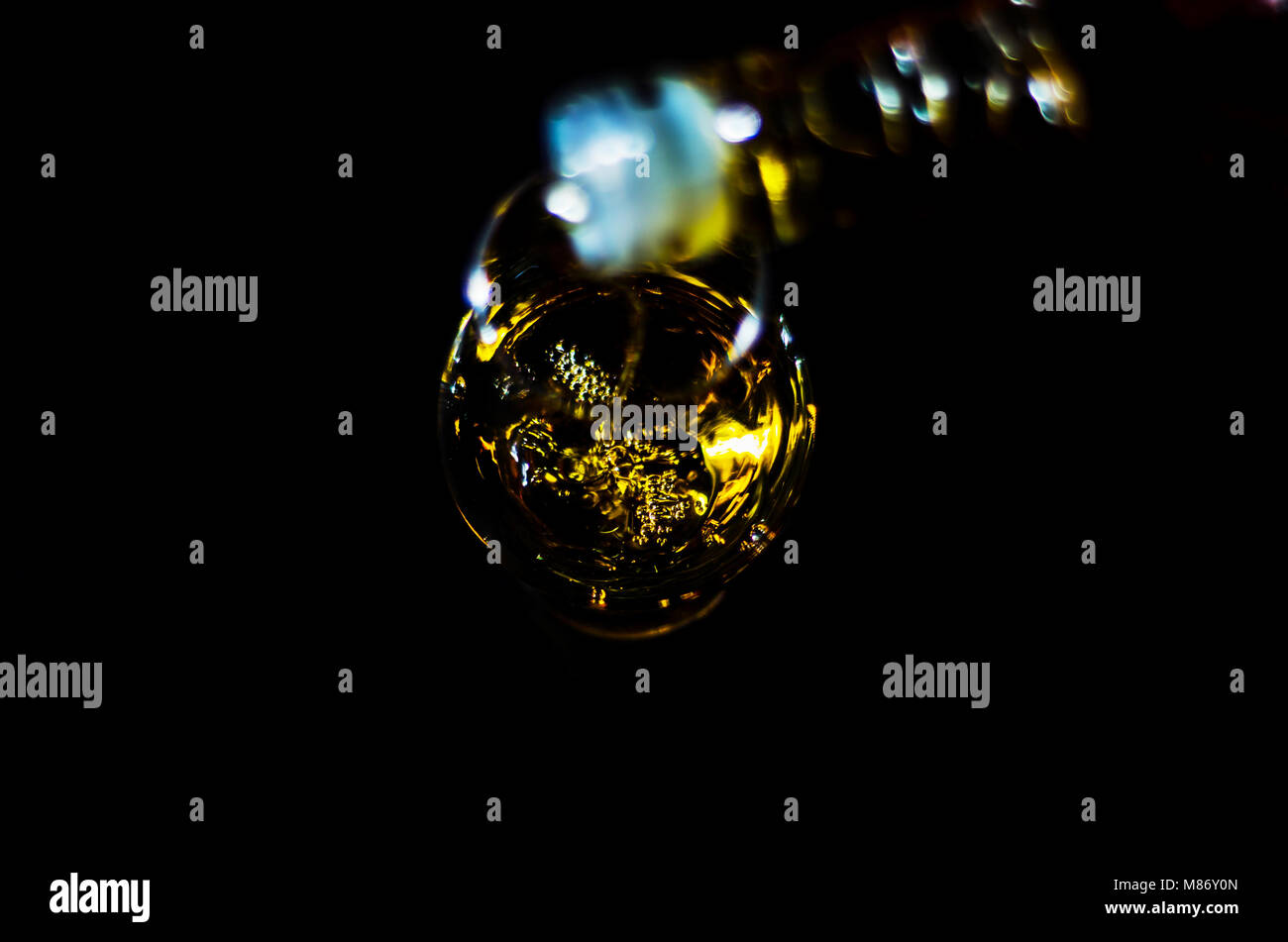 pouring single malt whisky into a glass, golden color whisky, an ...
