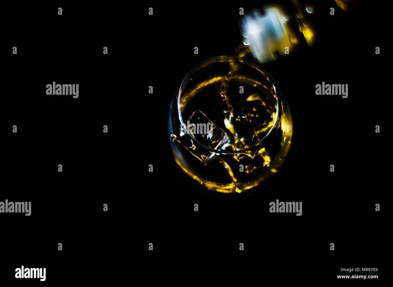 pouring single malt whisky into a glass, golden color whisky, an ...