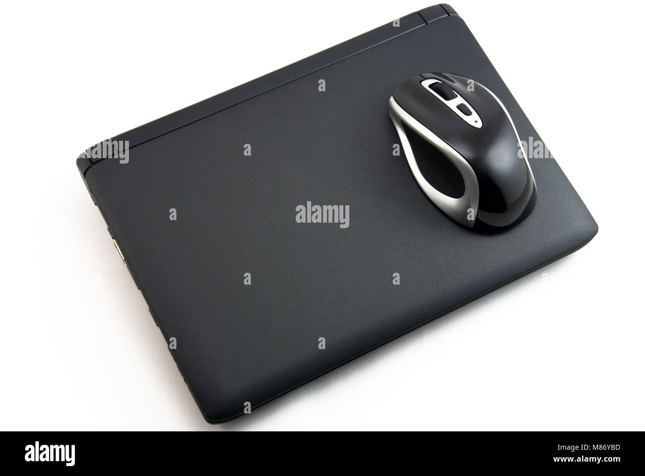 The wireless mouse lies on the closed laptop with a matte surface Stock ...