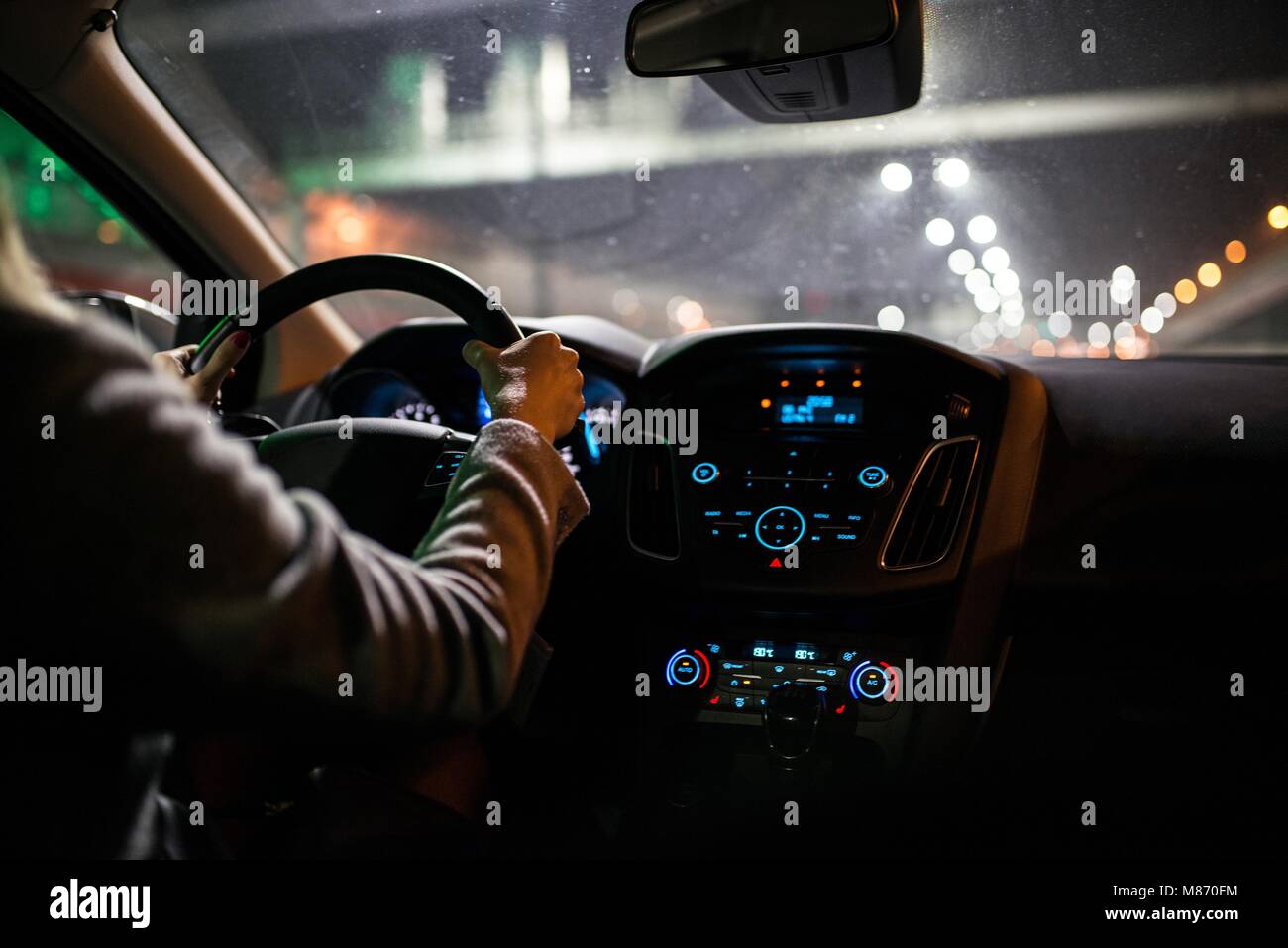 Young woman driving a car at night. Modern car interior Stock Photo - Alamy