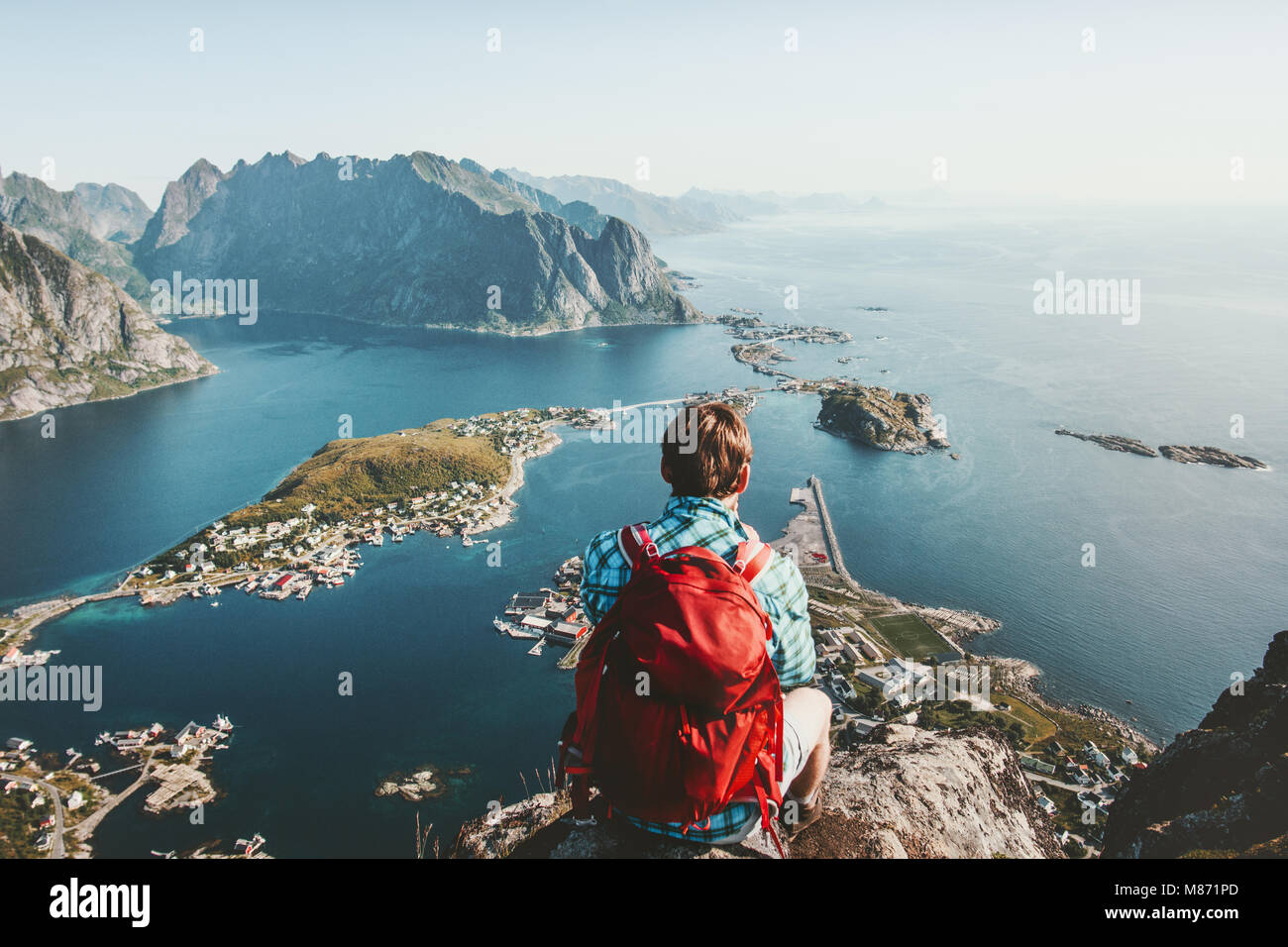 Man sitting on cliff edge alone enjoying aerial view backpacking lifestyle travel adventure ...