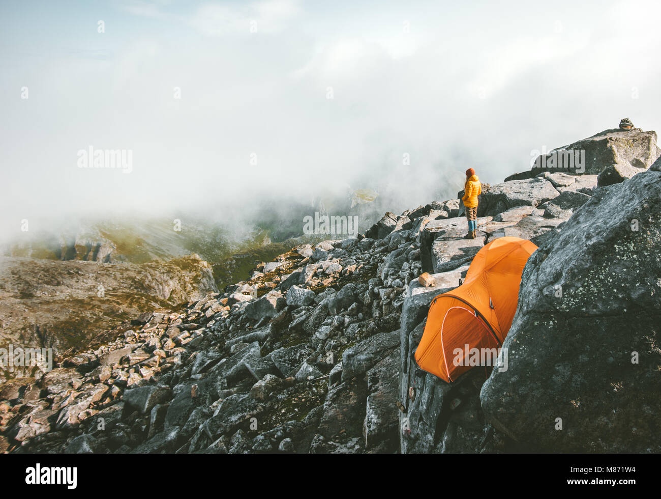 Camping on the top of mountain tent on rocky cliff and traveler alone ...