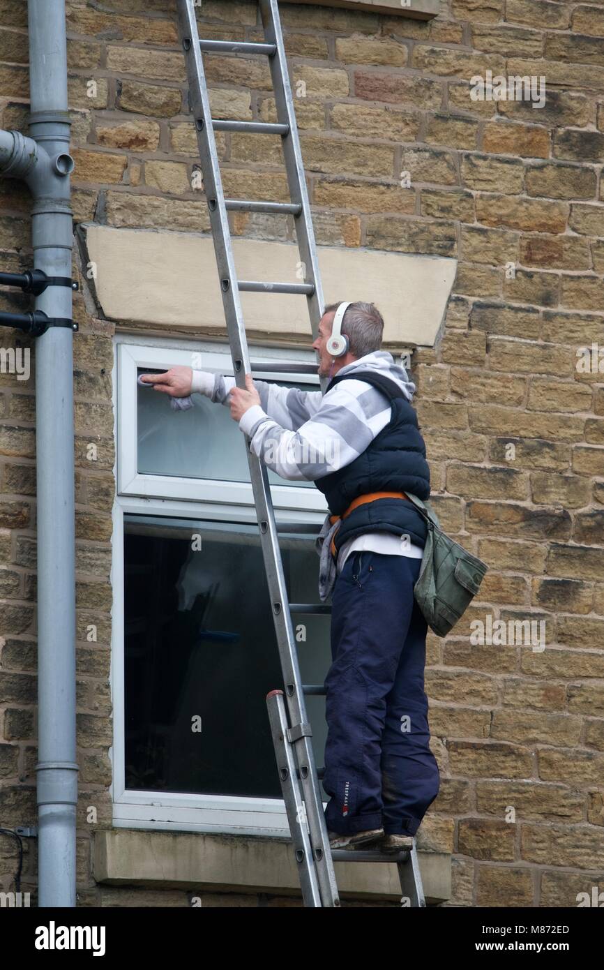 A window cleaner at work in New Mills, Derbyshire Stock Photo - Alamy