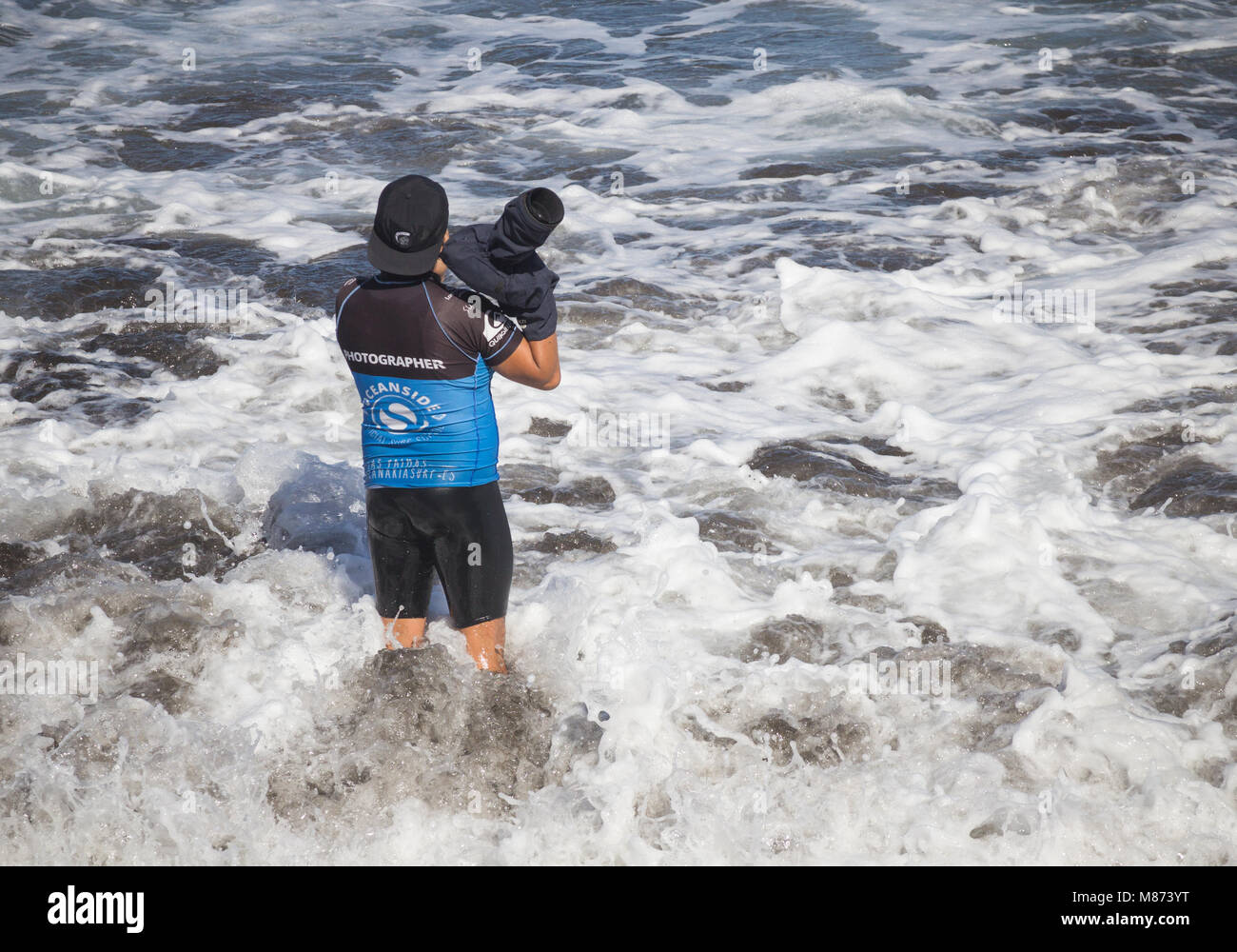 Surf photographer with protective cover on camera and lens Stock Photo ...