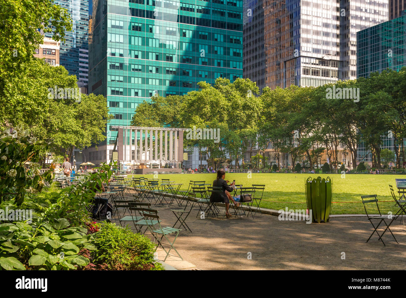 Woman sitting down at a table in bryant park hi-res stock photography ...