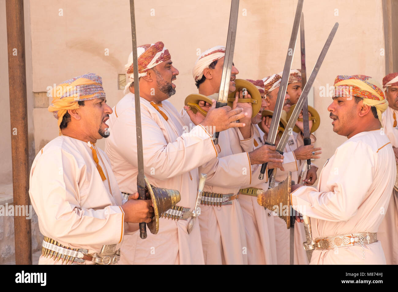 Nizwa, Oman - Omani men dancing a traditional sword dance at Nizwa Fort ...
