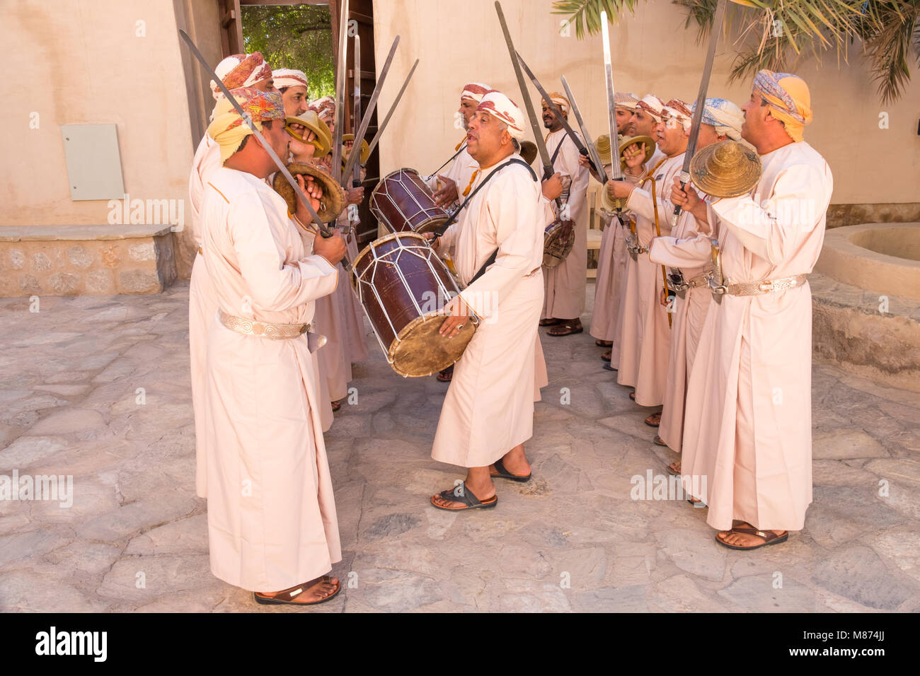 Nizwa, Oman - Omani men dancing a traditional sword dance at Nizwa Fort ...