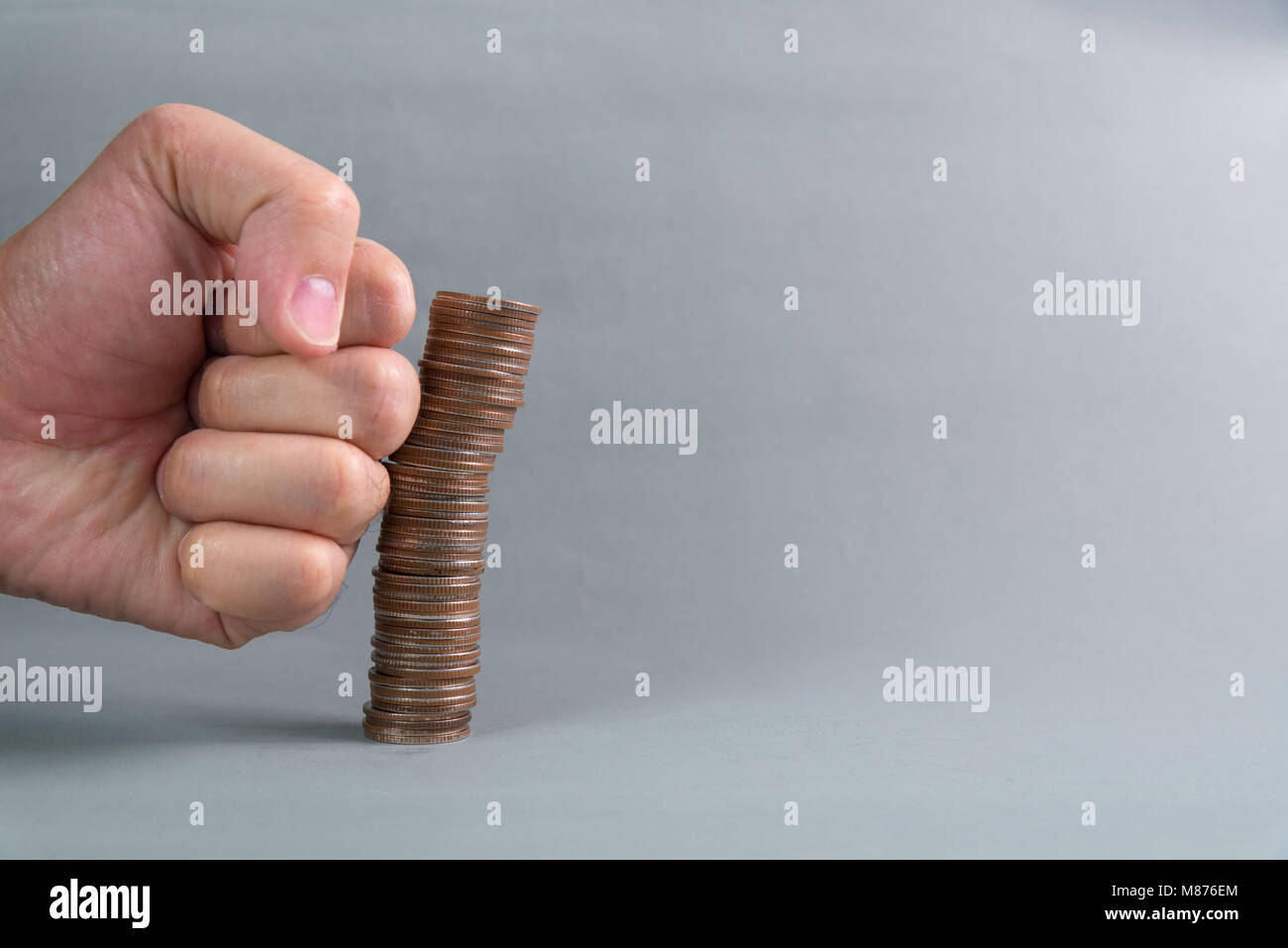 Hand punch the increasing columns of coins on white background, piles ...