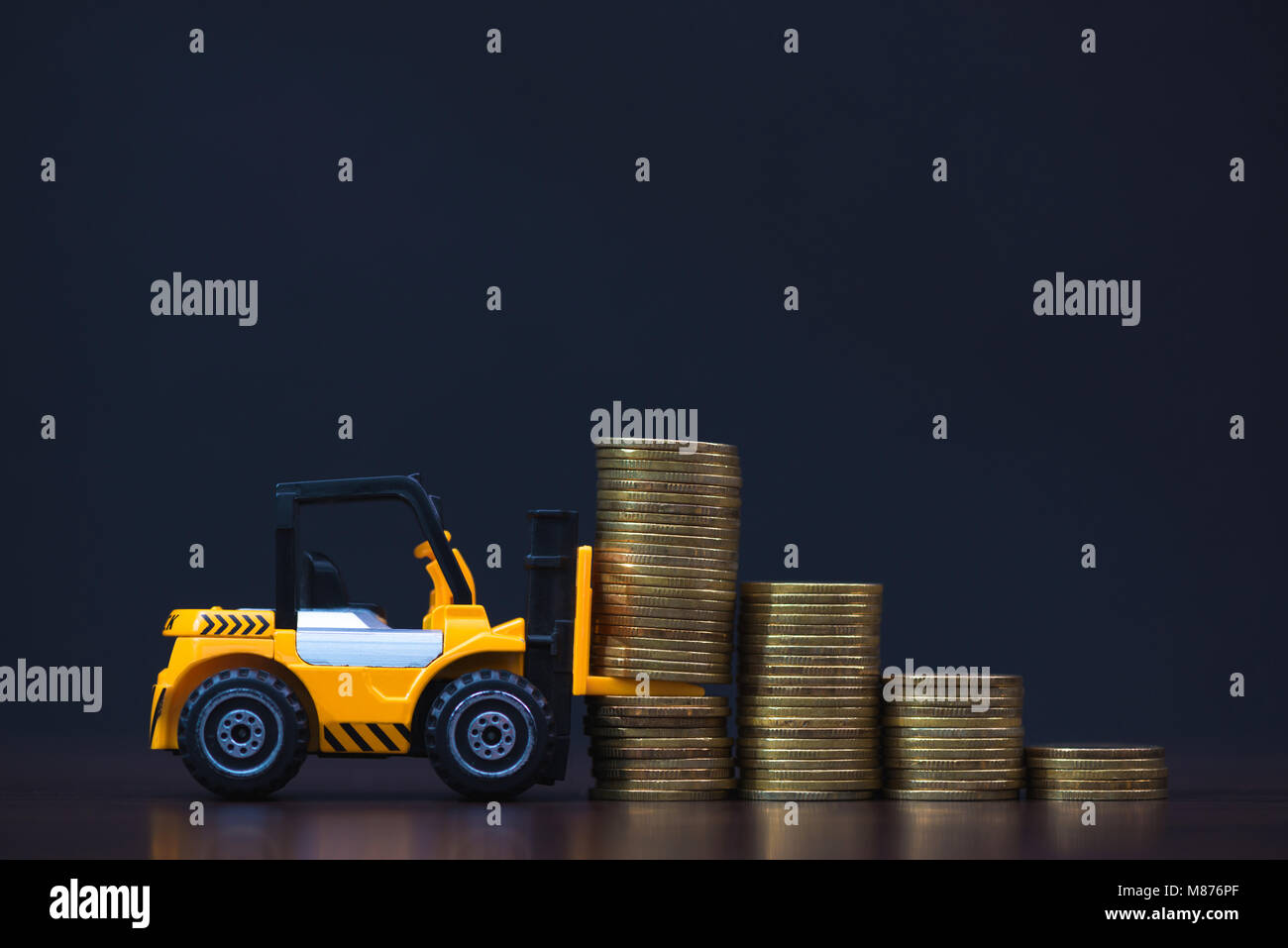 Mini forklift truck loading stack coin with steps of gold coin in dark ...