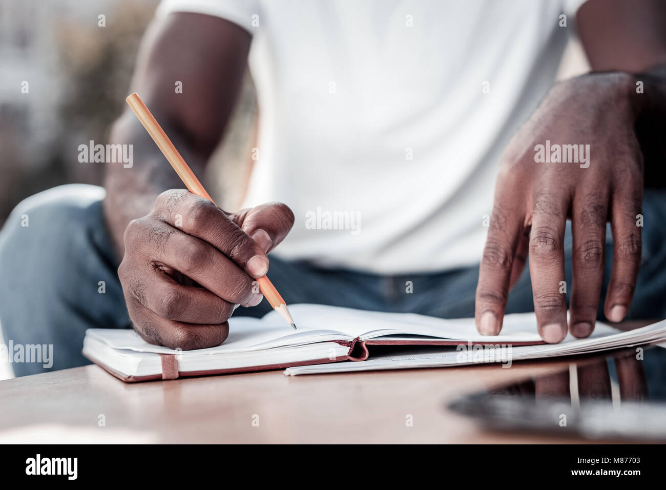 Close up of african american man taking notes Stock Photo - Alamy