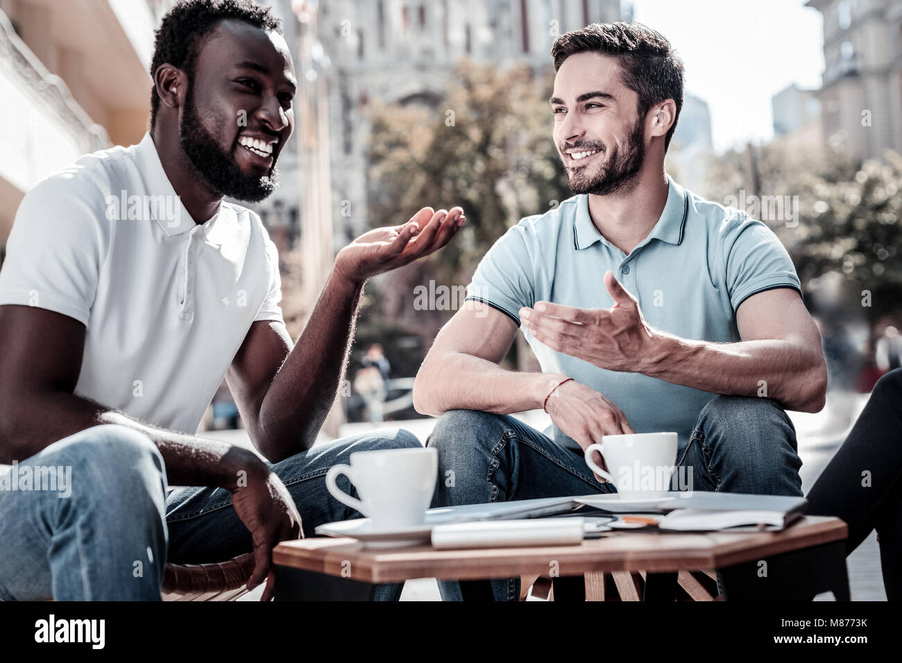 Friendly colleagues discussing their work outdoors Stock Photo - Alamy