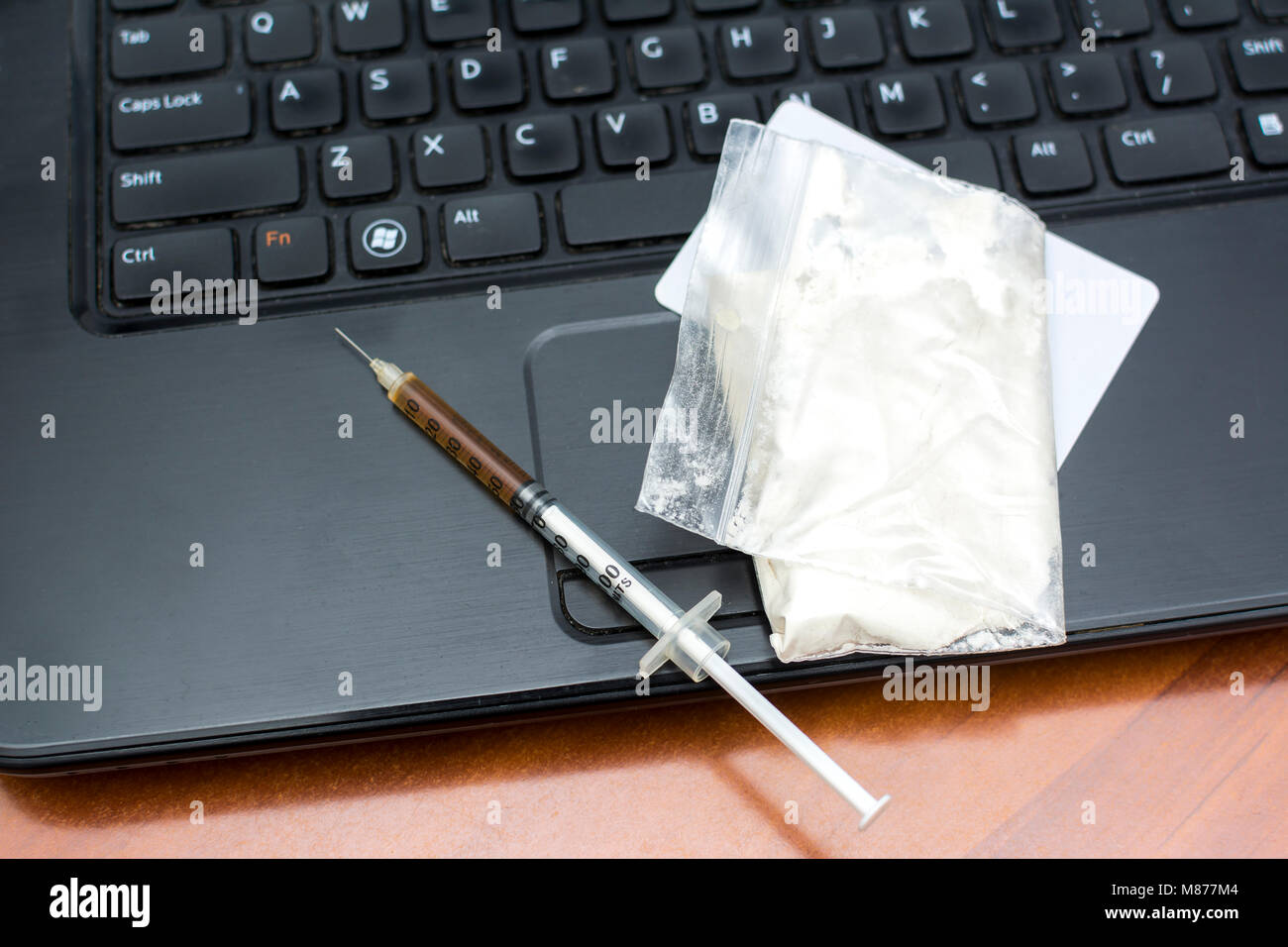 Drugs powder and a syringe on desk office. Drug addiction ...