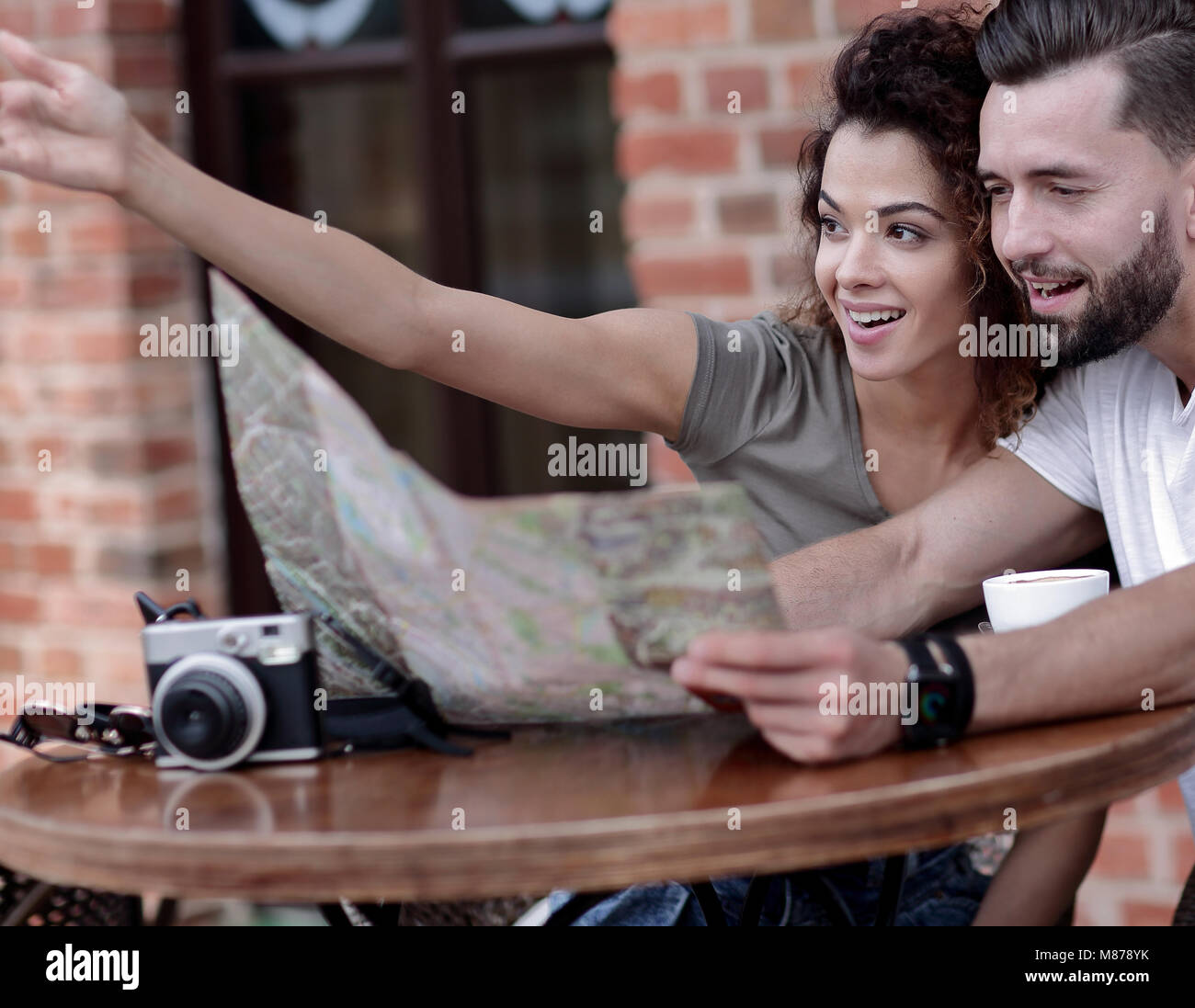 Young tourists having coffee at cafe and reading map Stock Photo - Alamy