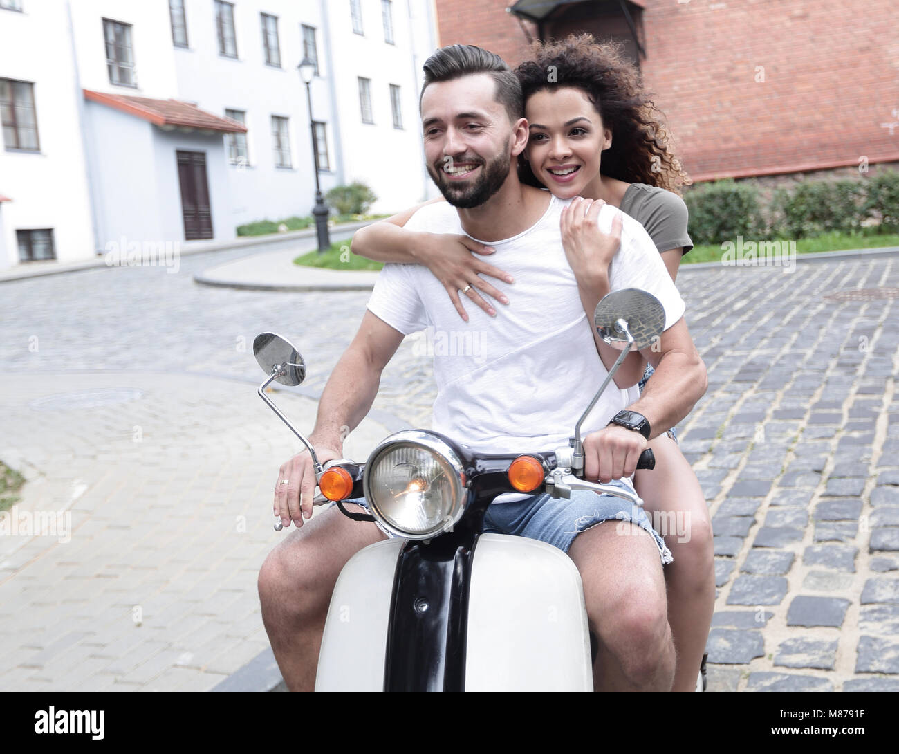 Young couple riding motor scooter in city Stock Photo - Alamy