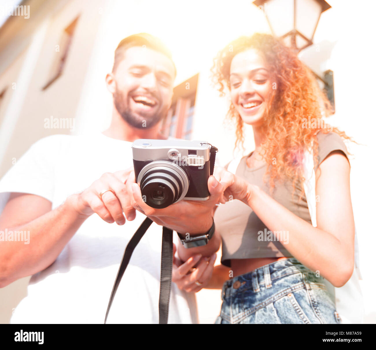Portrait of young friends walking looking at the photos Stock Photo - Alamy