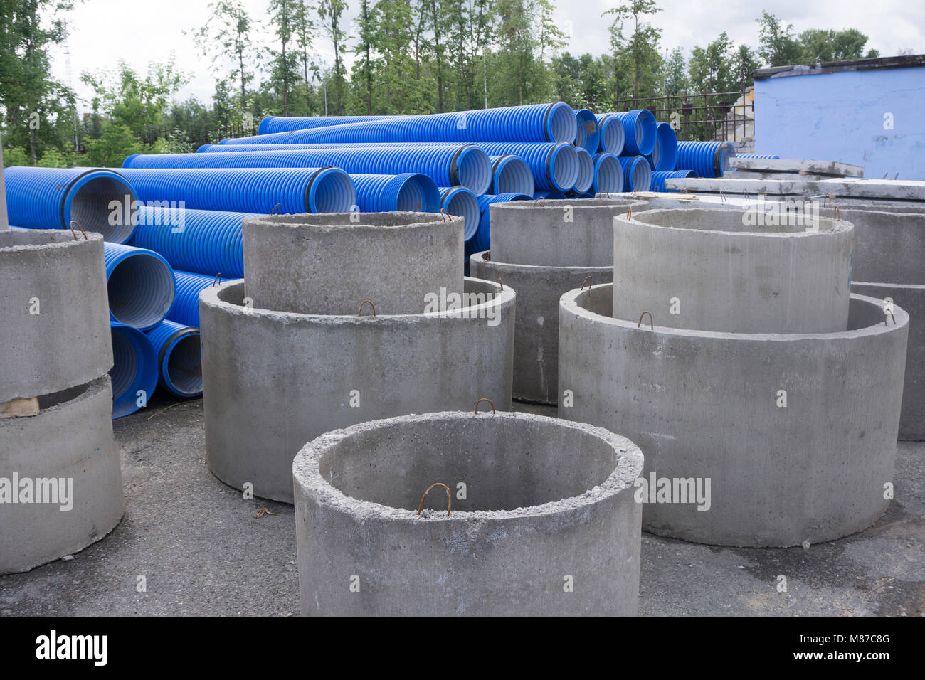 Concrete ring wells with different diameters and gray lie in the street ...