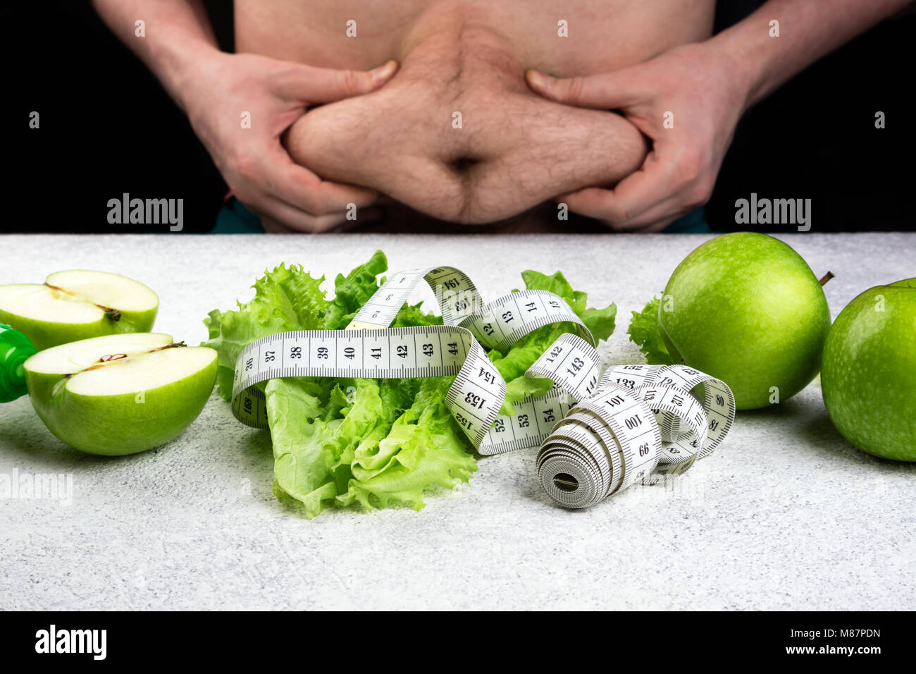 Man with fat belly and table with healthy eating. Dieting, slimming ...