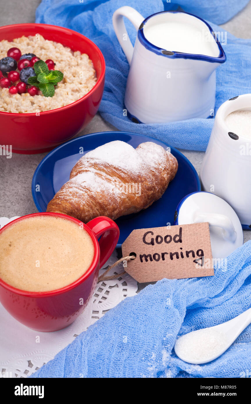 Traditional breakfast with oatmeal porridge, croissants, yogurt and ...