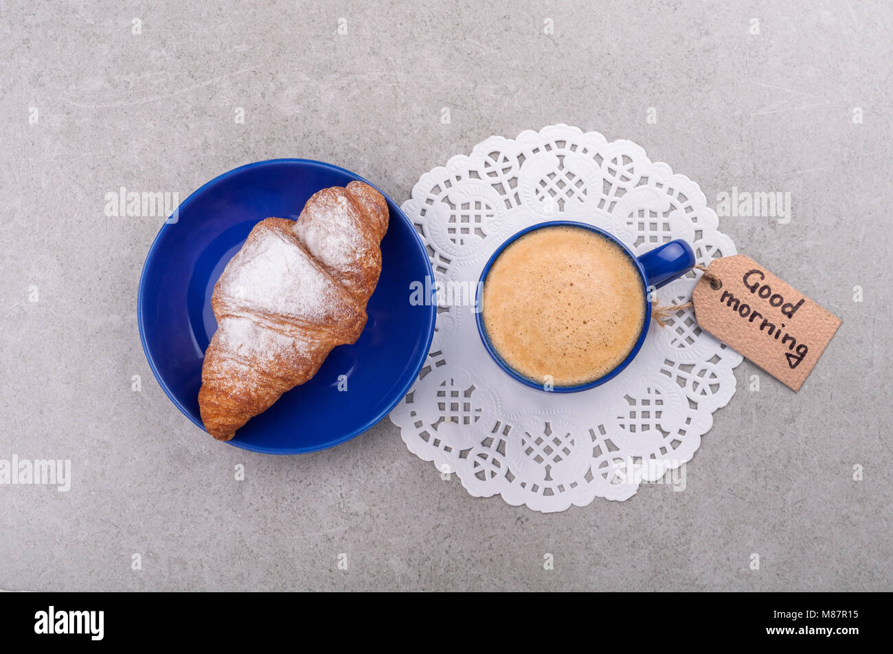 Coffee cup, croissant and note good morning on grey background ...