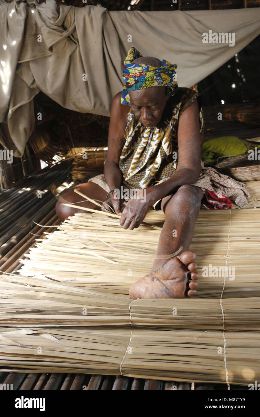 Woman braids sleeping mats in her house Stock Photo - Alamy
