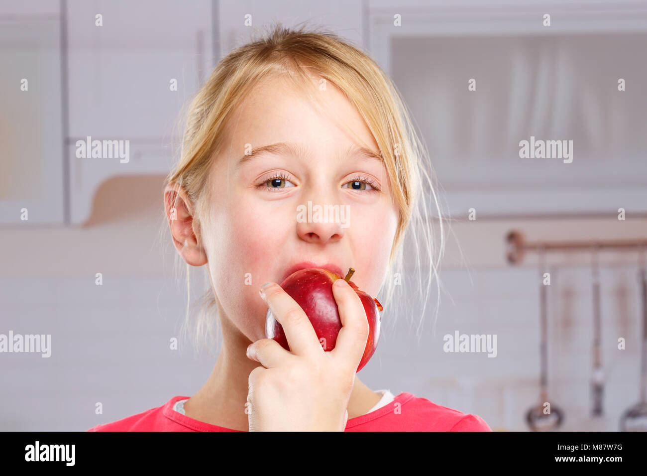 Girl child kid eating apple fruit autumn fall healthy kitchen Stock ...