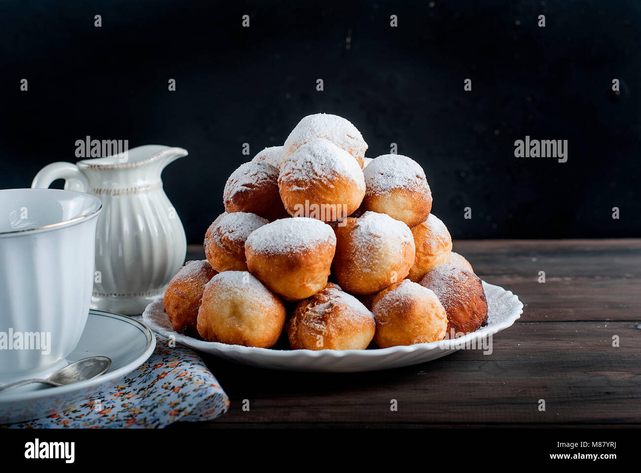 sweet donuts laid out pyramid sprinkled with powdered sugar on the ...