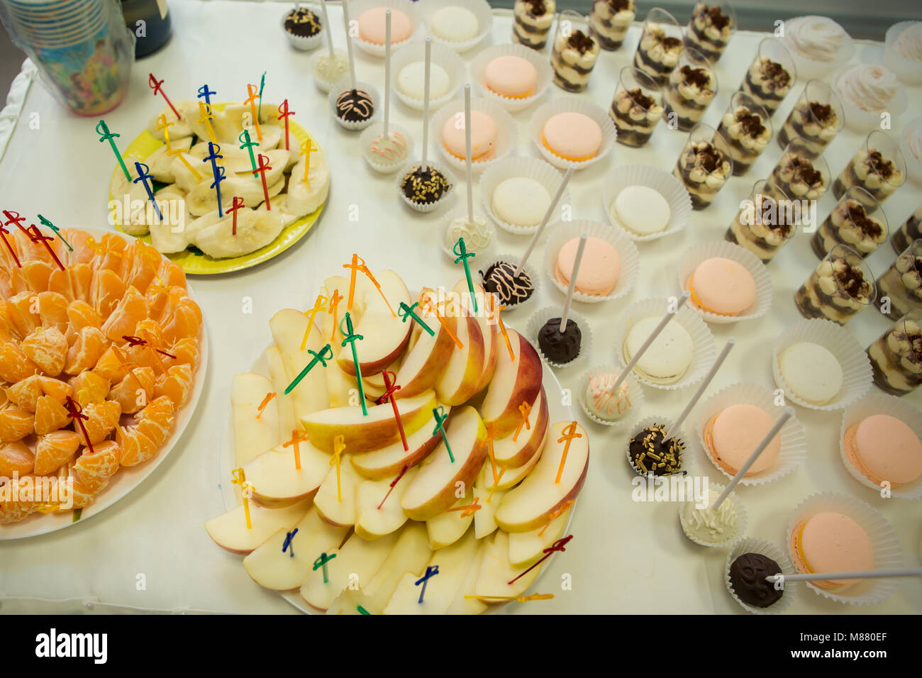 assorted fruits with skewers and tasty sweets served on white table ...