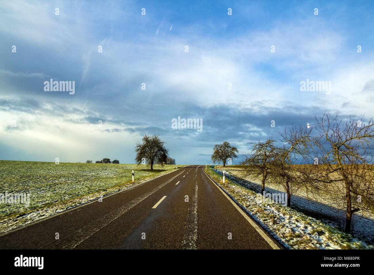 Empty black asphalt road between green fields Stock Photo - Alamy