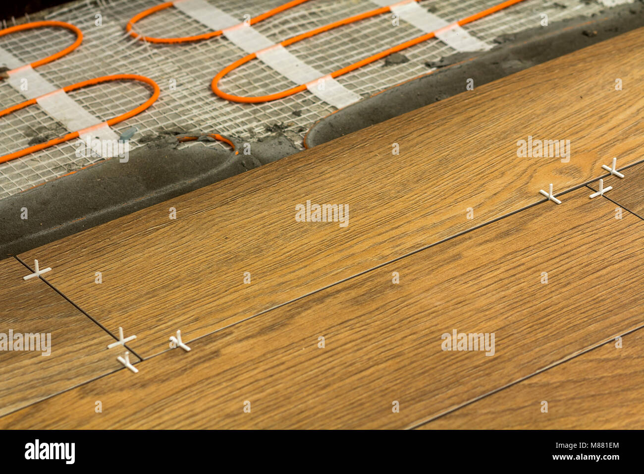 Installation of ceramic tiles and heating elements in warm tile floor ...